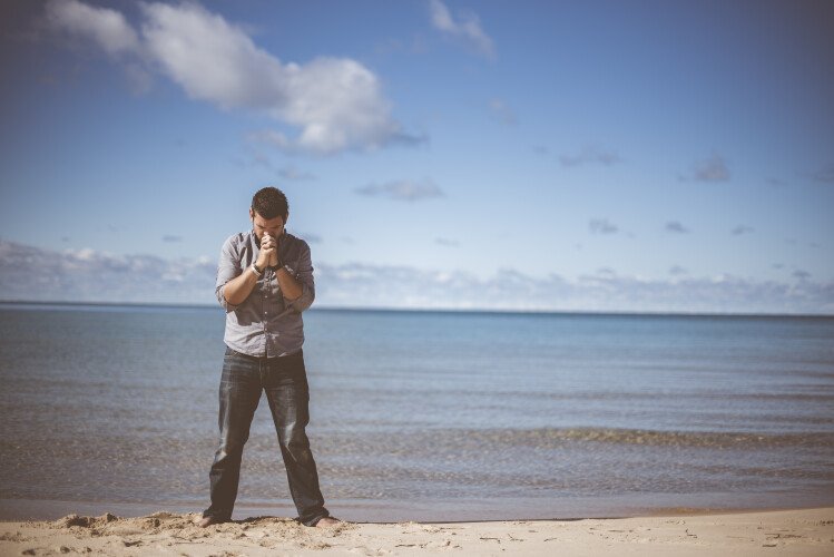 Man Praying on Beach