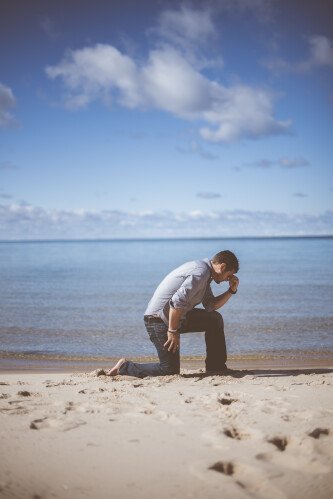 Man Praying on Beach