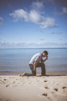 Man Praying on Beach