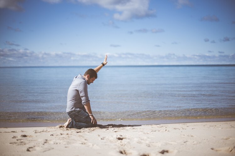 Man Praying on Beach