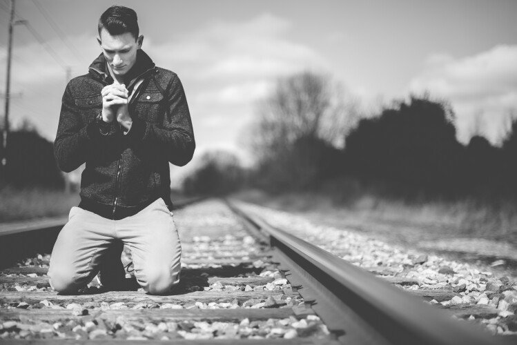 Man Praying on Train Tracks