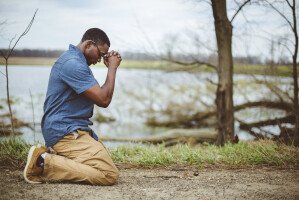 Man Kneeling Praying Outdoors
