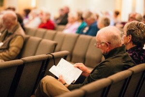 A Man Reading A Bible During Church