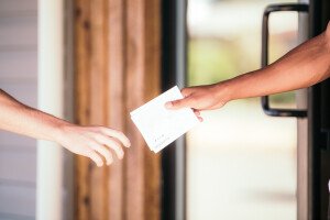 A Man Giving A Piece Of Paper To Someone